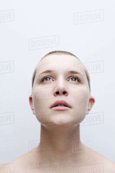 Woman with shaved-head looking up - Stock Photo - Dissolve