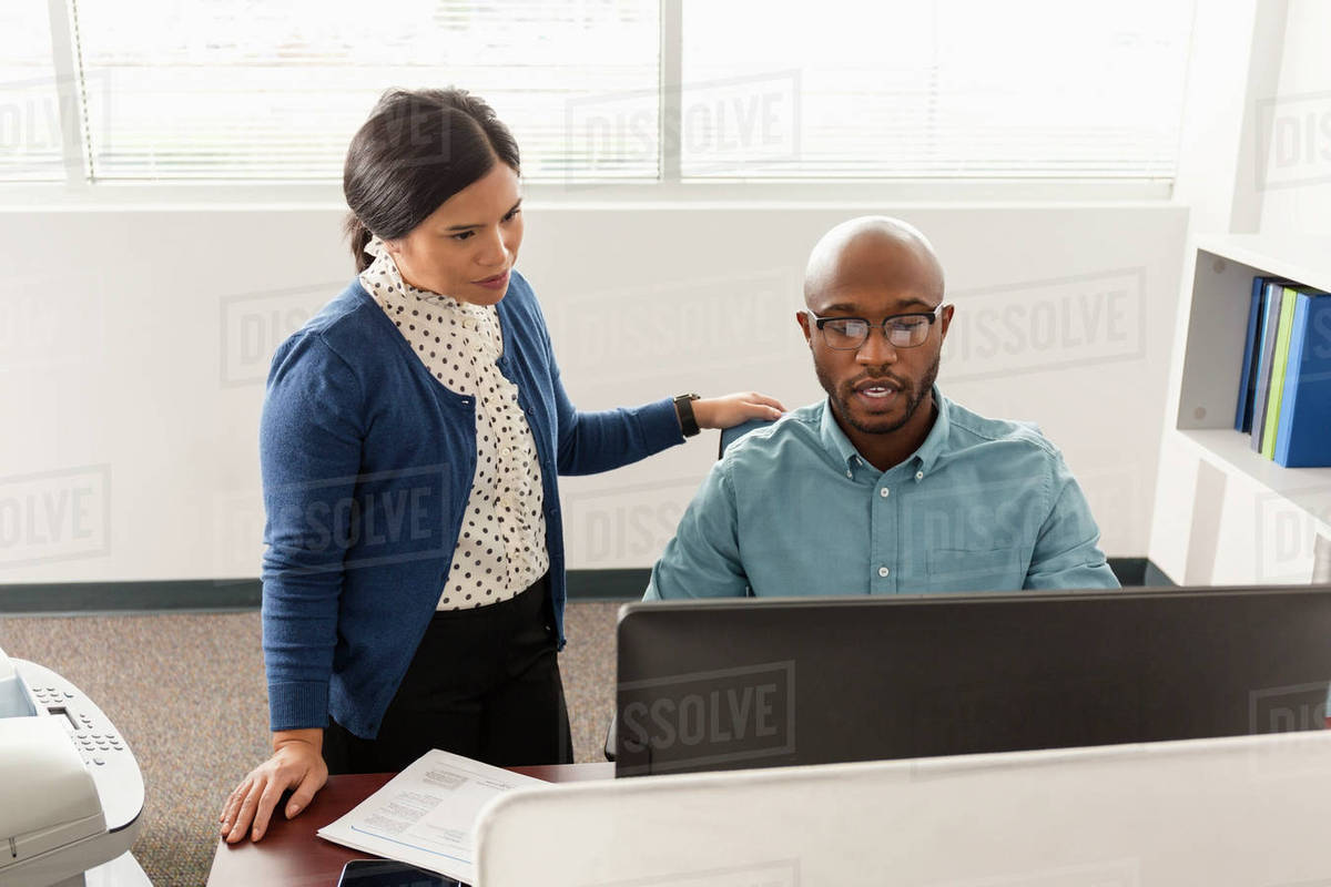 Man and woman working at computer in office - Stock Photo - Dissolve