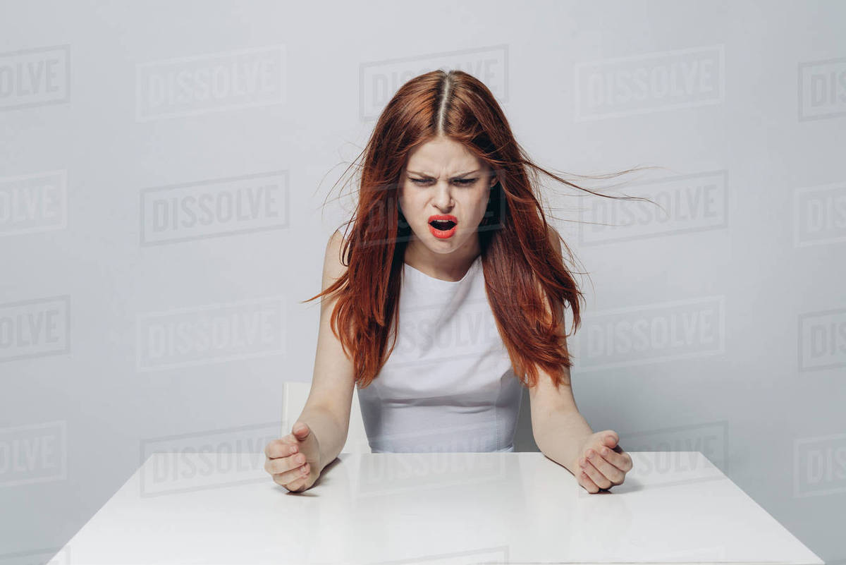 Angry Caucasian woman sitting at windy table - Royalty-free Stock Photo ...