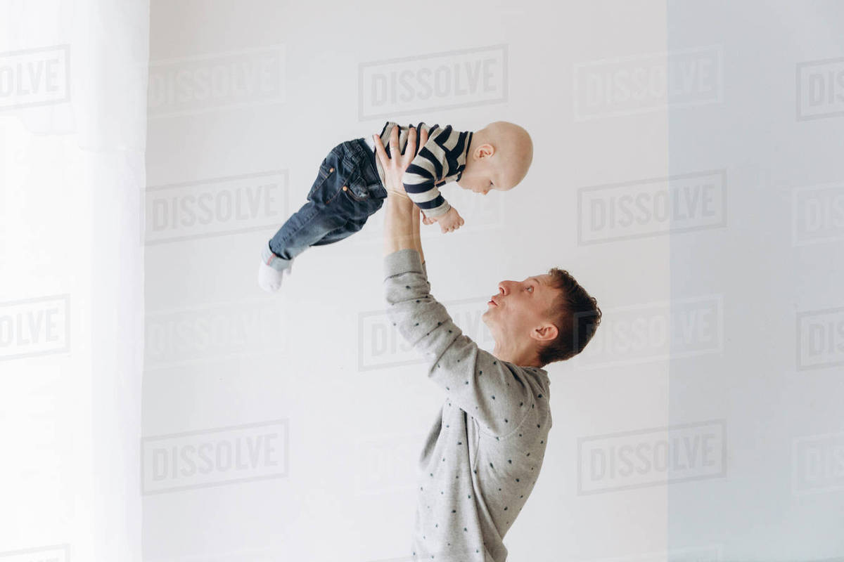 Caucasian father lifting baby son - Royalty-free Stock Photo | Dissolve