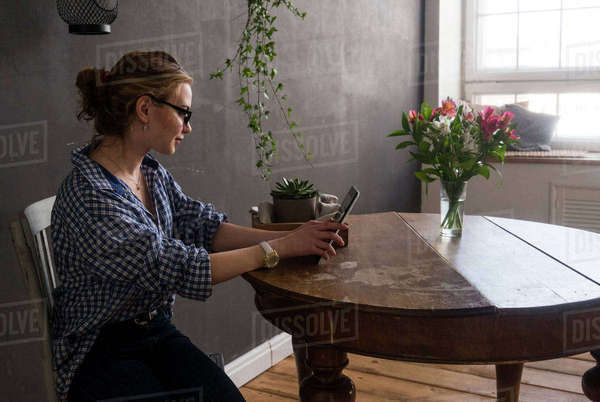Caucasian woman sitting at table using digital tablet - Royalty-free ...