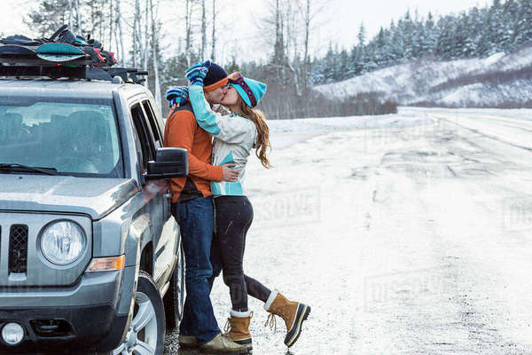 Caucasian couple kissing near car in winter - Royalty-free Stock Photo ...