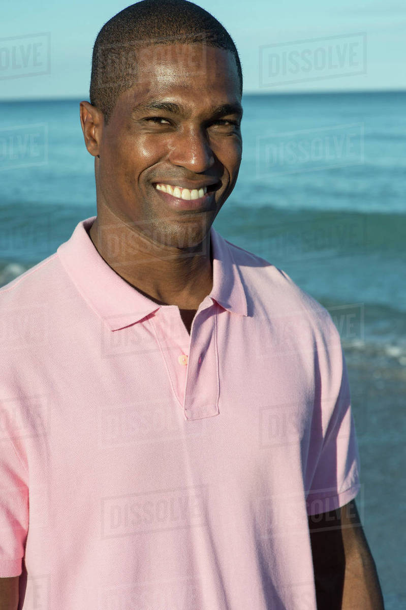 Portrait of smiling Black man on beach - Royalty-free Stock Photo ...