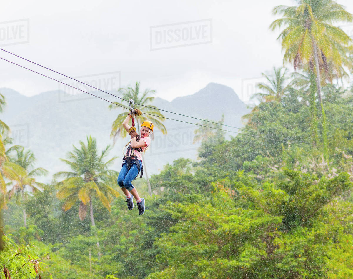 Caucasian girl hanging on zip line in forest - Royalty-free Stock Photo ...