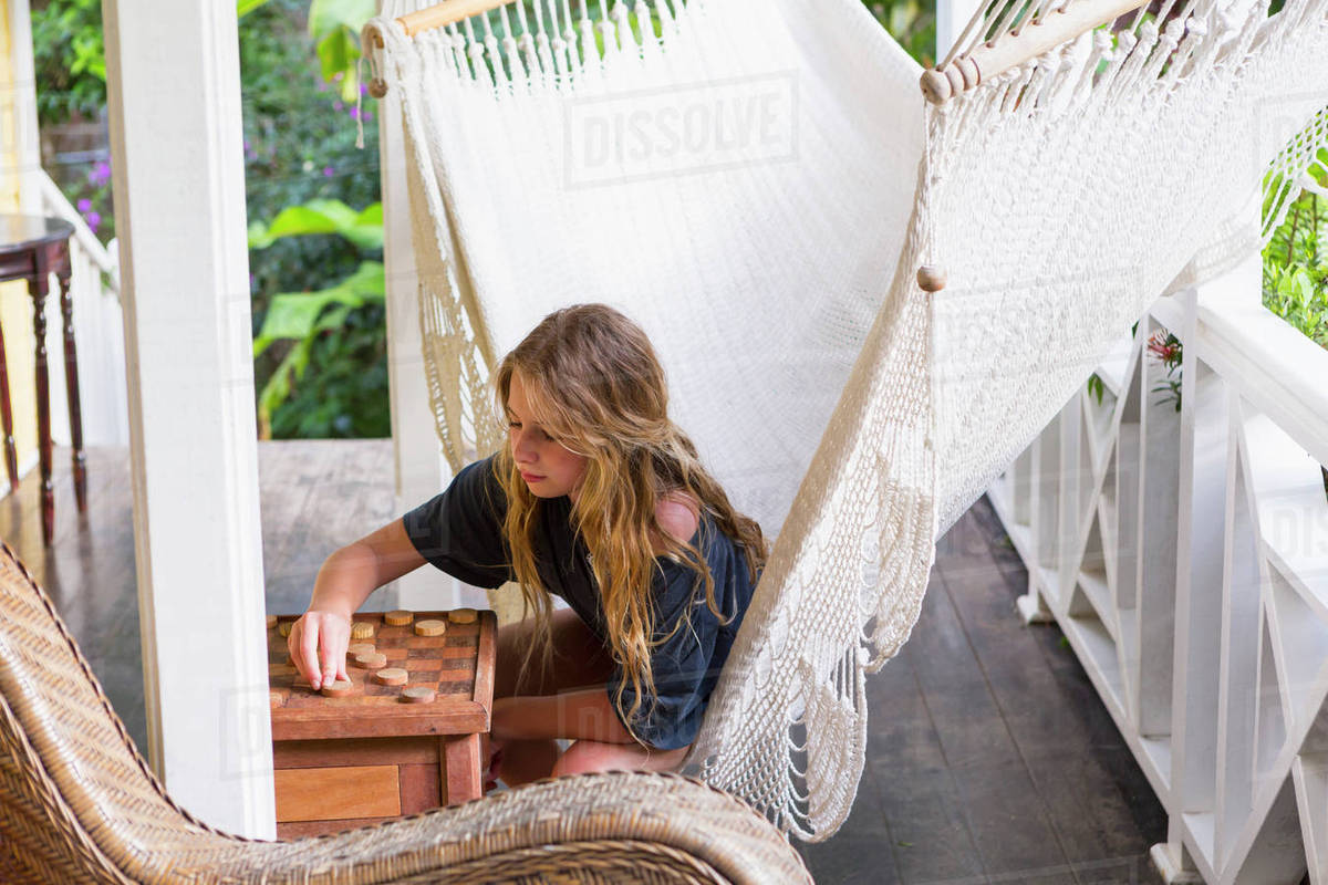 Caucasian girl sitting in hammock playing checkers - Royalty-free Stock ...