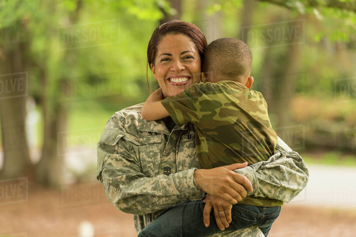 African American soldier mother carrying and hugging son - Royalty-free ...