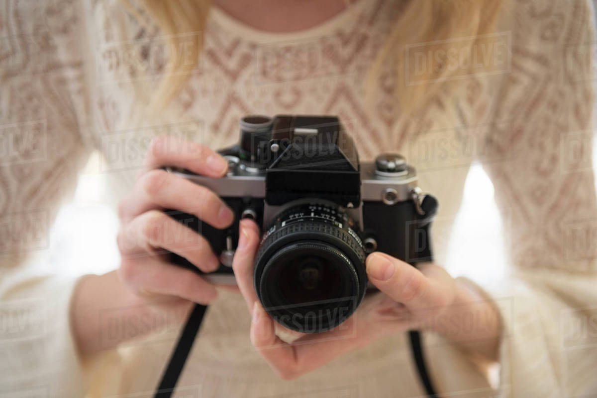 Hands of Caucasian woman focusing lens on camera - Stock Photo - Dissolve