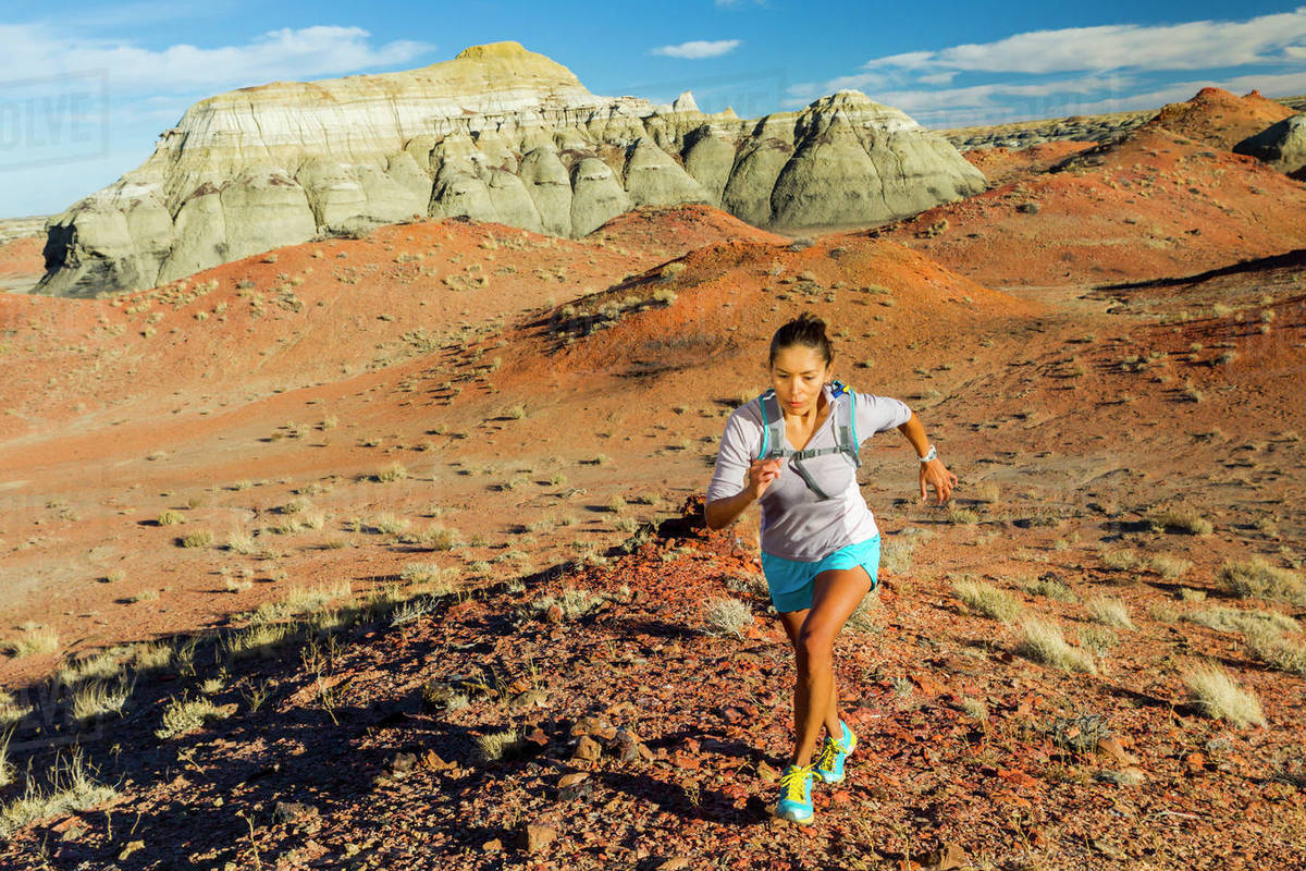 Native American woman running in desert - Stock Photo - Dissolve