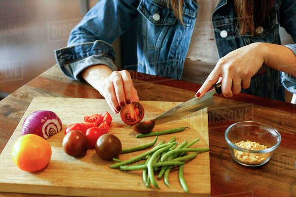 Woman chopping vegetables on cutting board - Stock Photo - Dissolve