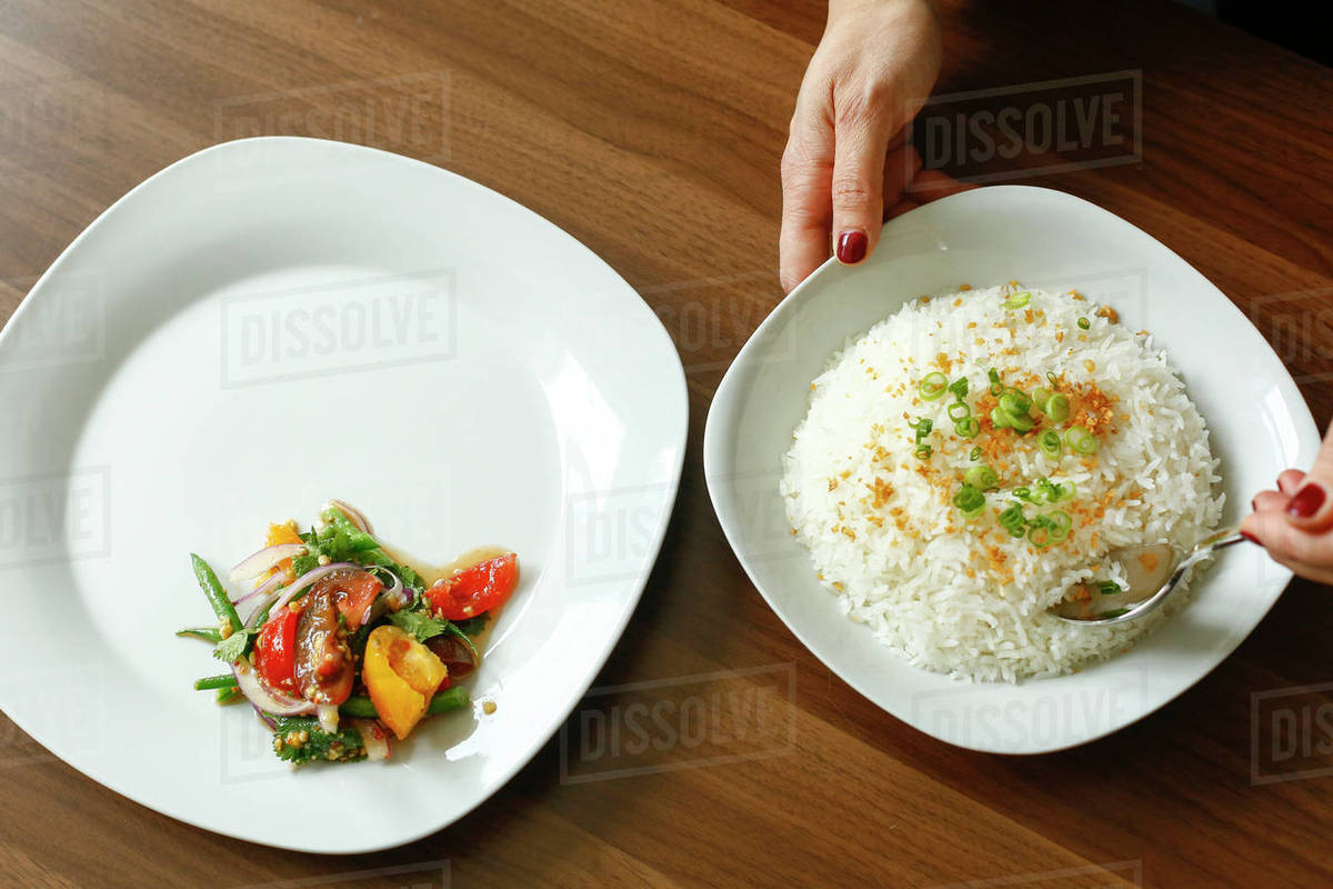 Hands of woman serving rice - Royalty-free Stock Photo | Dissolve