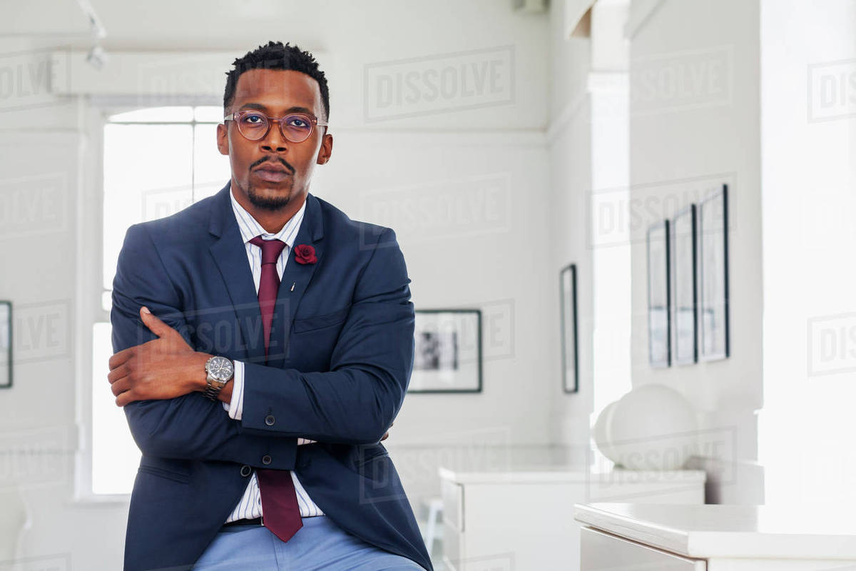 Black man with arms crossed in gallery - Stock Photo - Dissolve