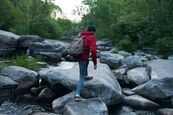 Caucasian man hiking on rocks in river - Royalty-free Stock Photo ...