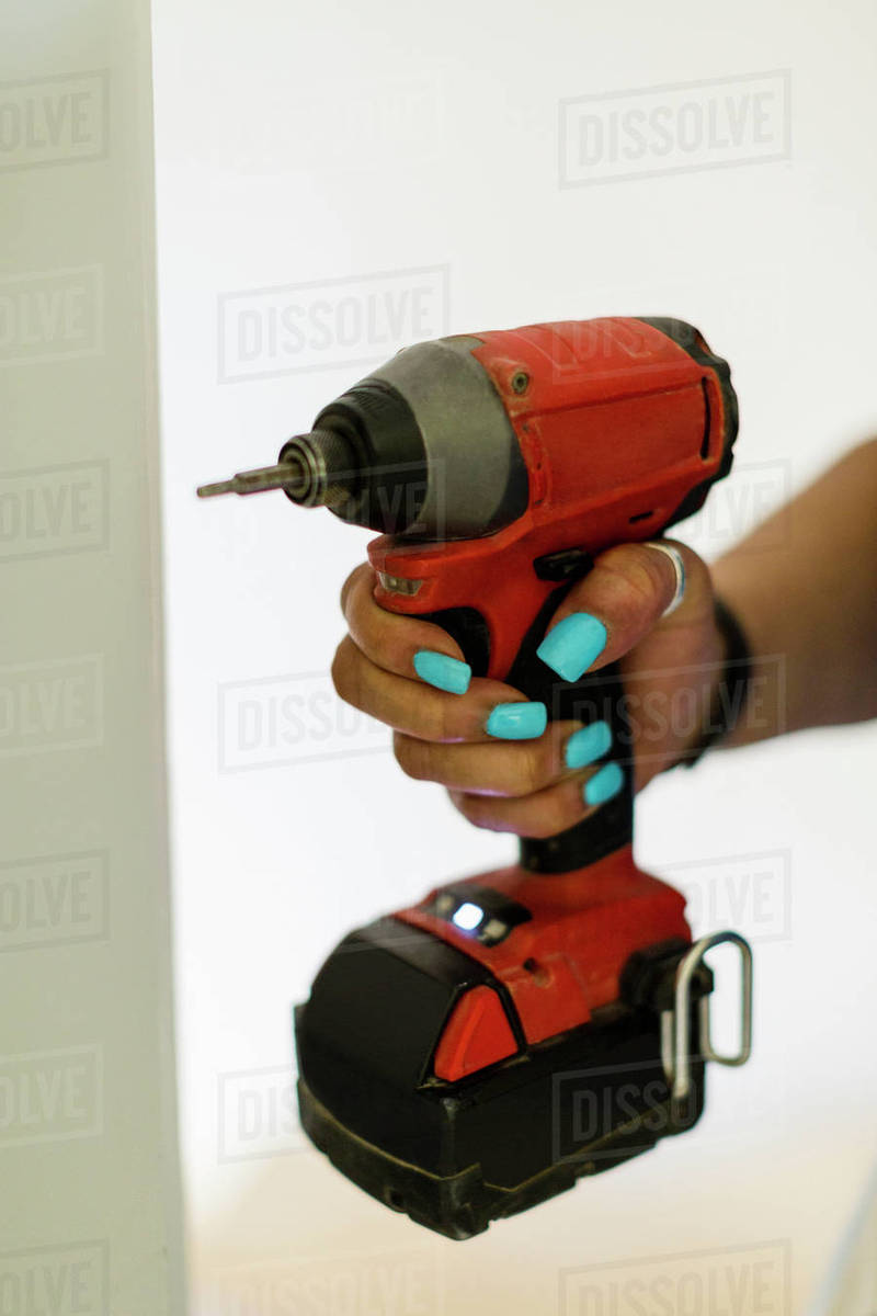 Hand of black woman holding drill - Stock Photo - Dissolve