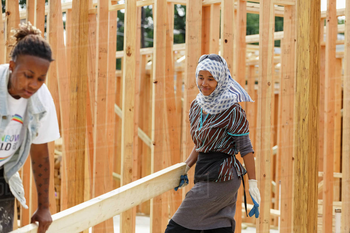 Volunteers carrying lumber at construction site - Royalty-free Stock ...