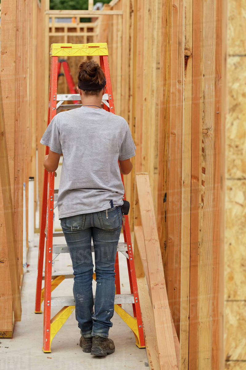 Caucasian woman pushing ladder at construction site - Royalty-free ...