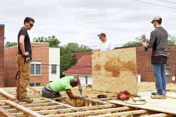 Volunteers working on the roof at construction site - Royalty-free ...