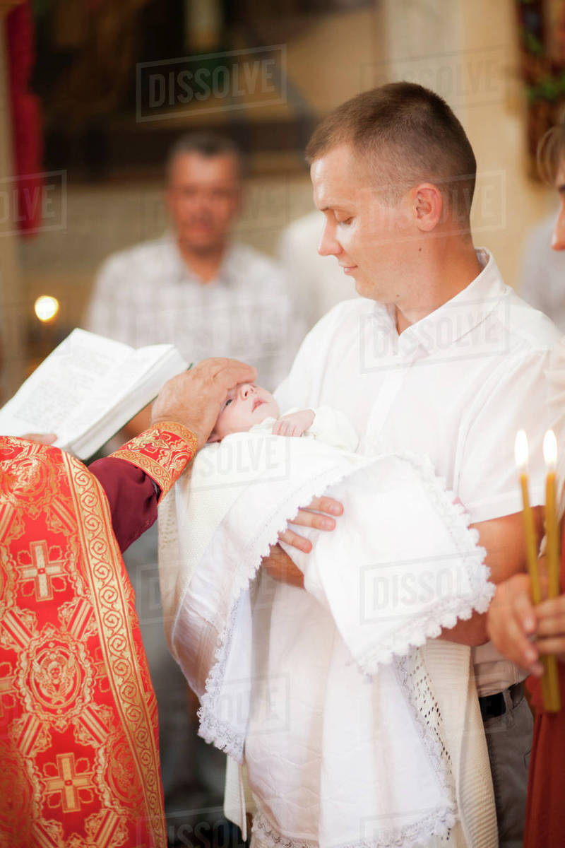 Priest blessing baby boy in church - Royalty-free Stock Photo | Dissolve