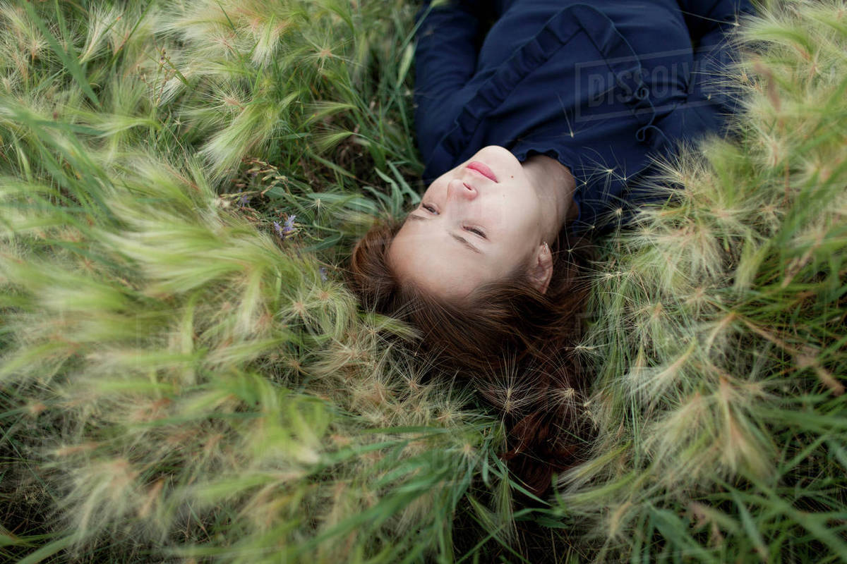 Pensive Caucasian girl laying in field - Royalty-free Stock Photo ...