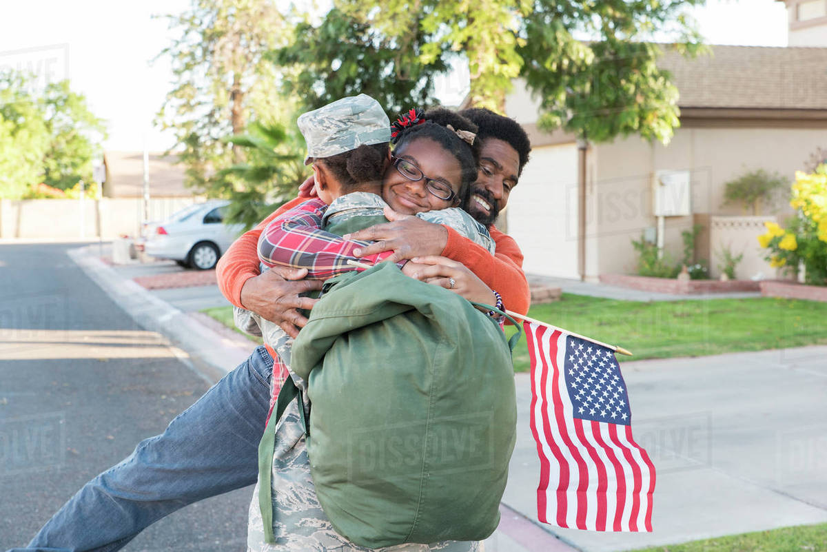 Black woman soldier hugging man and daughter - Stock Photo - Dissolve