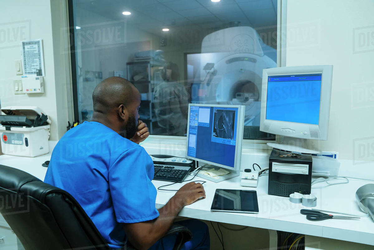 Black nurse using computer near scanner - Royalty-free Stock Photo ...