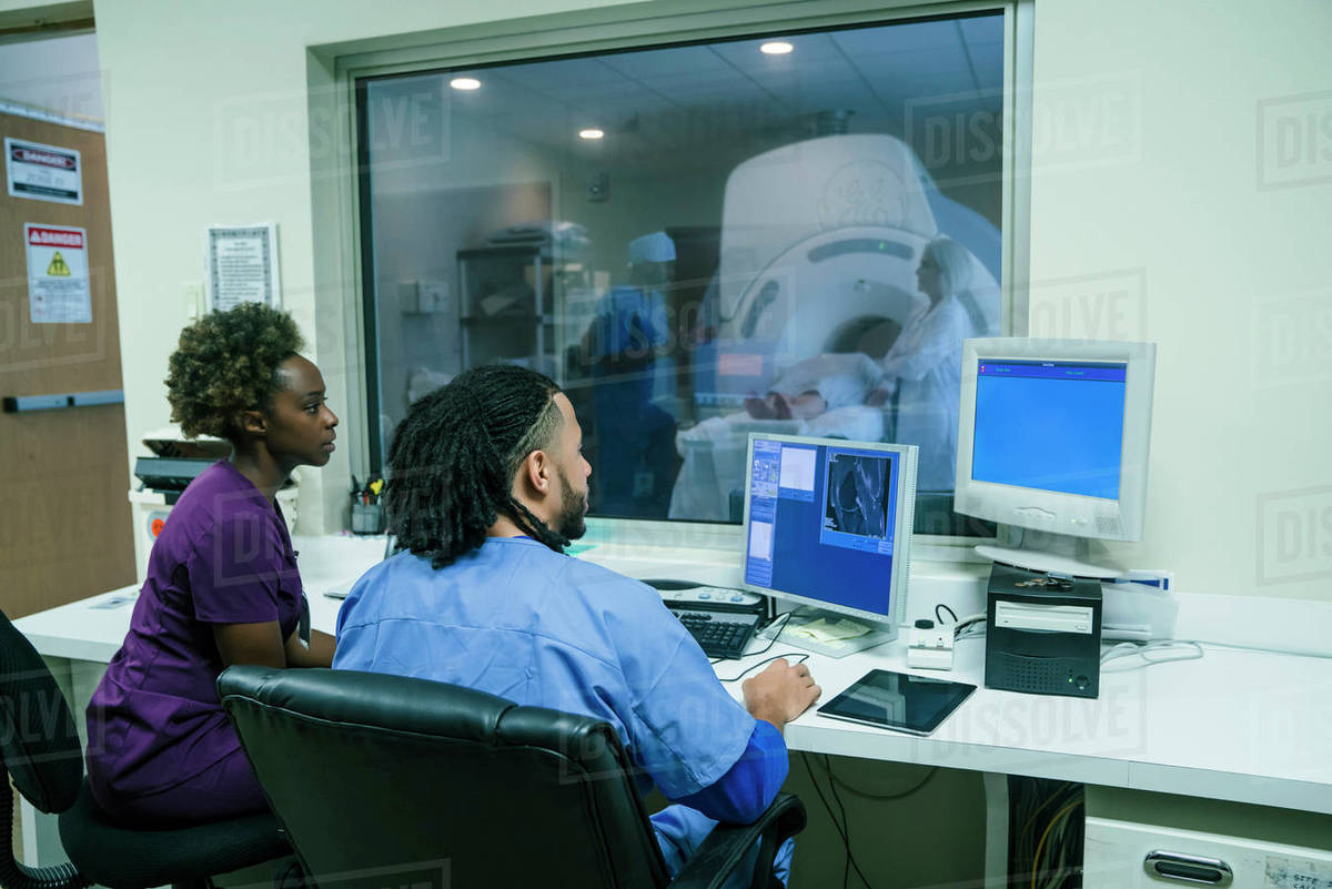 Nurses using computer near scanner - Stock Photo - Dissolve