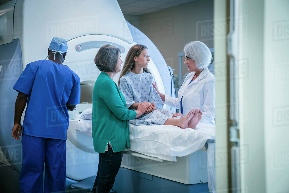 Doctor comforting patient at scanner - Royalty-free Stock Photo | Dissolve