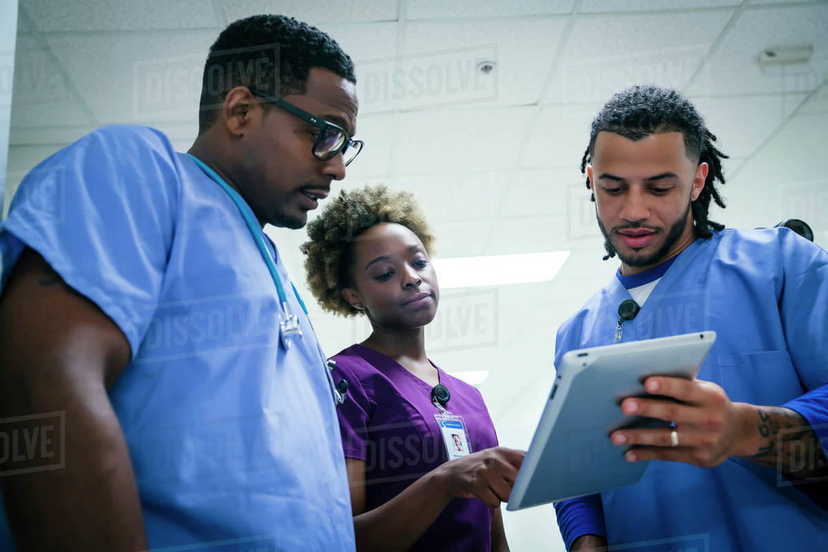 Nurses discussing digital tablet - Stock Photo - Dissolve