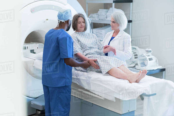 Doctor and nurse helping patient at scanner - Royalty-free Stock Photo ...