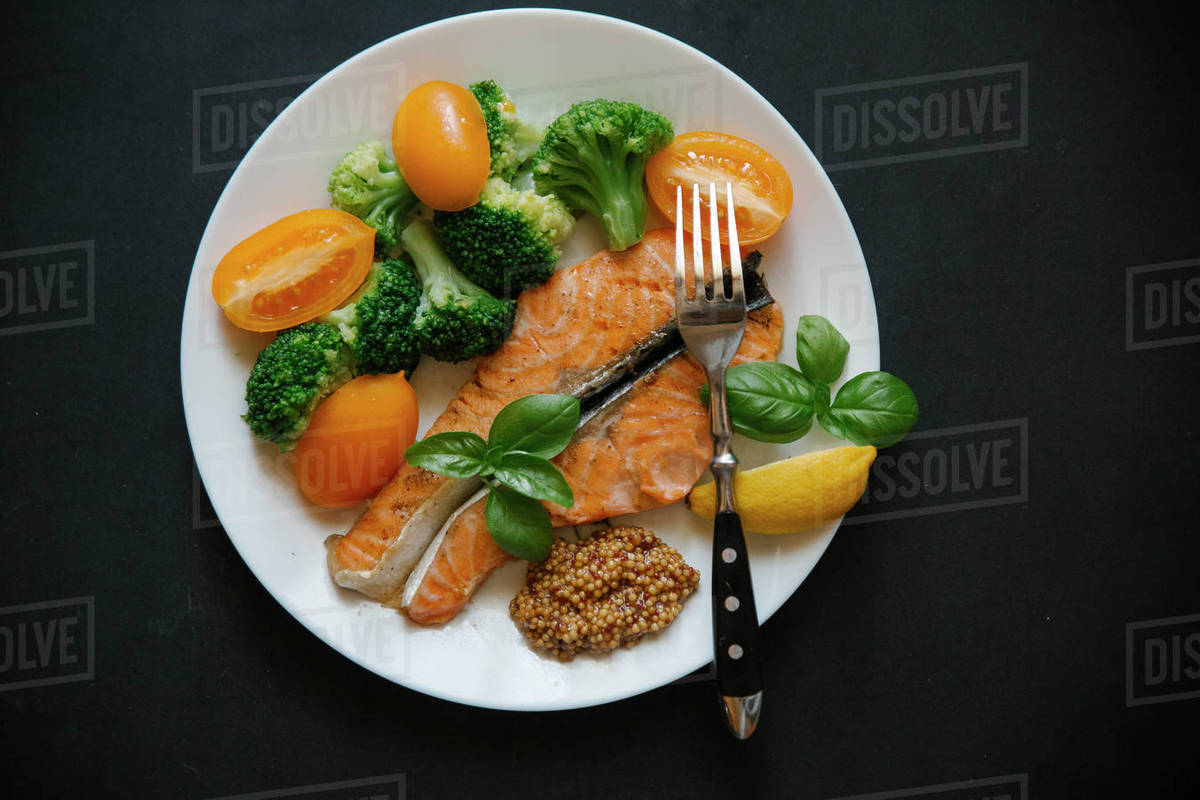Cooked salmon on plate with broccoli and tomatoes - Royalty-free Stock ...