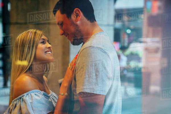 Smiling Caucasian couple behind window - Stock Photo - Dissolve