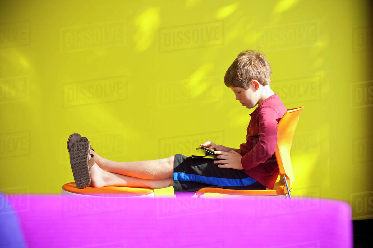 Caucasian boy relaxing and reading digital tablet - Royalty-free Stock ...