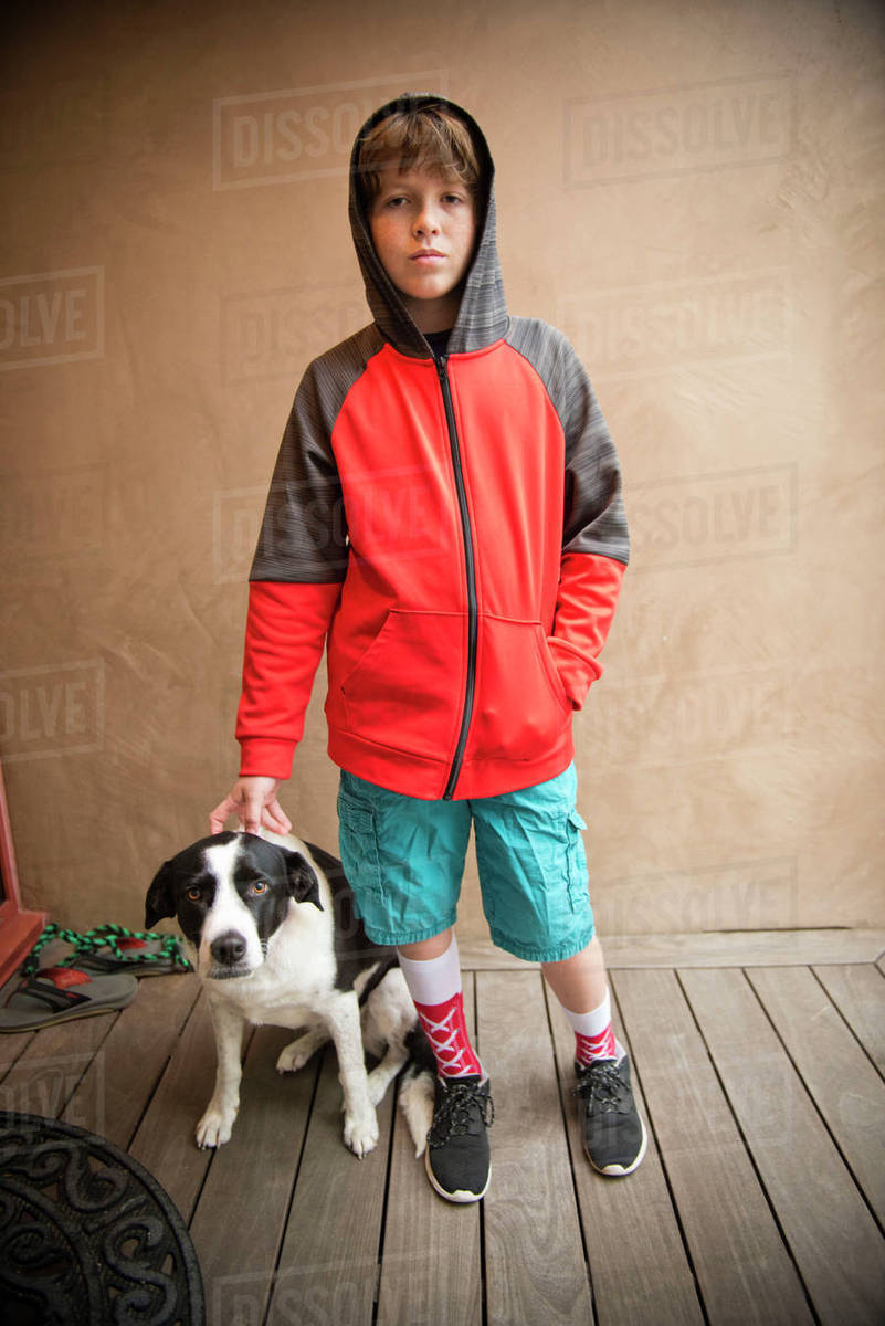 Portrait of Caucasian boy standing with dog - Royalty-free Stock Photo ...