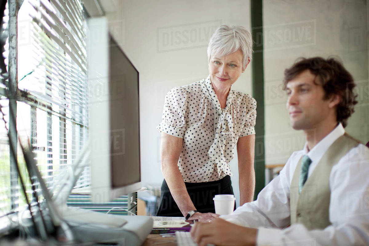 Business people using computer in office - Stock Photo - Dissolve