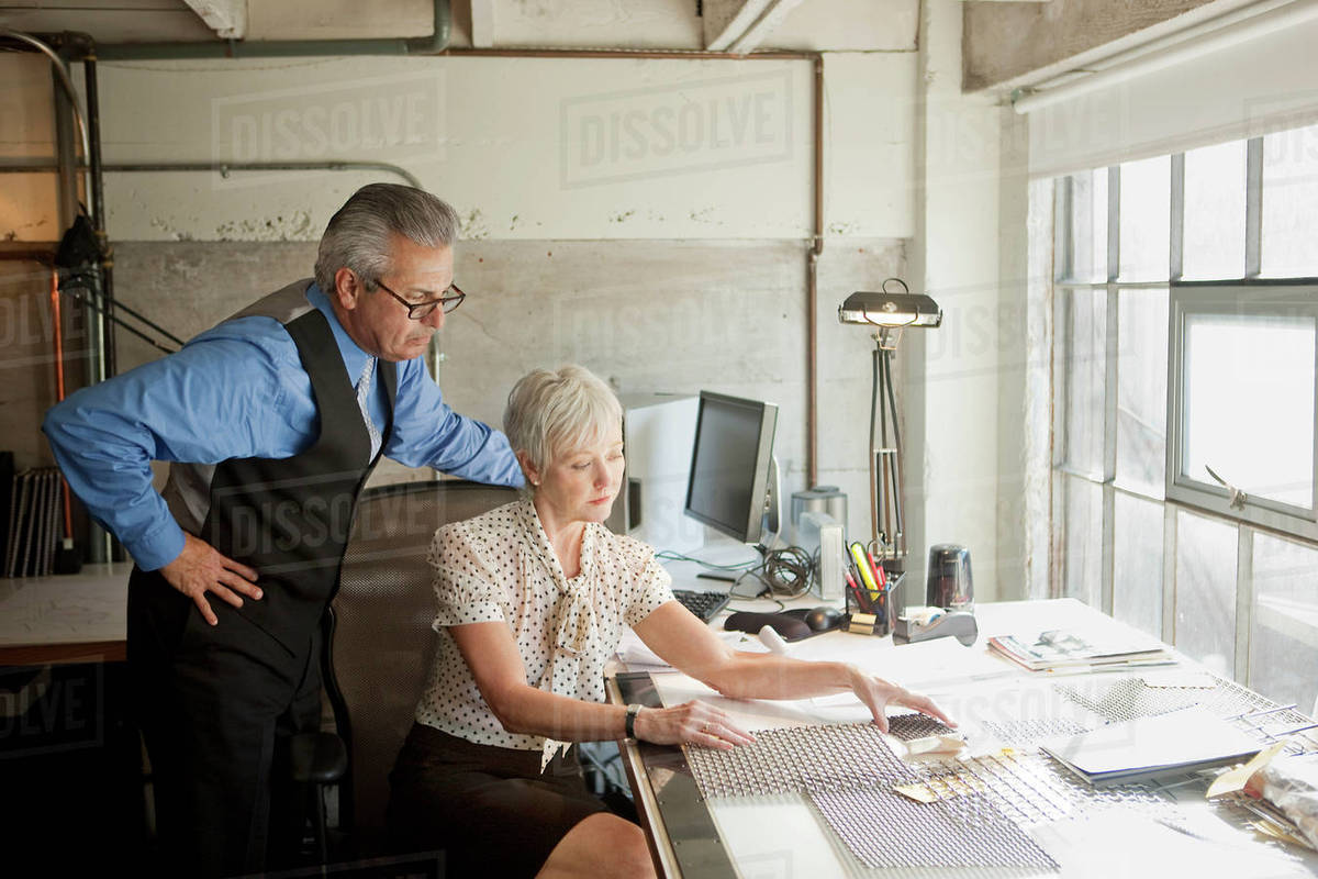 Business people examining parts in office - Stock Photo - Dissolve