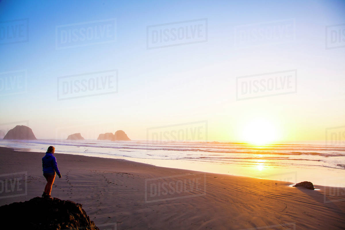 Caucasian woman overlooking sunrise on beach - Royalty-free Stock Photo ...