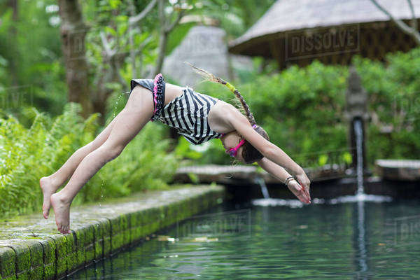 Caucasian girl diving into swimming pool - Stock Photo - Dissolve