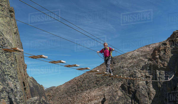 Caucasian man crossing rope bridge on mountain - Royalty-free Stock ...