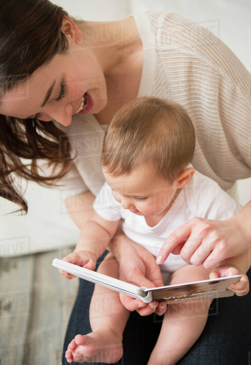 Mother and baby reading in living room - Stock Photo - Dissolve