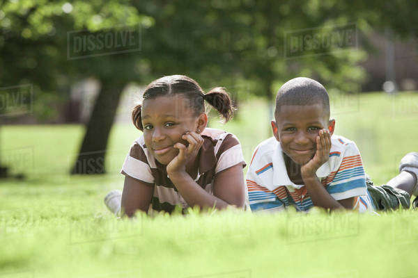 African American children laying in park - Stock Photo - Dissolve