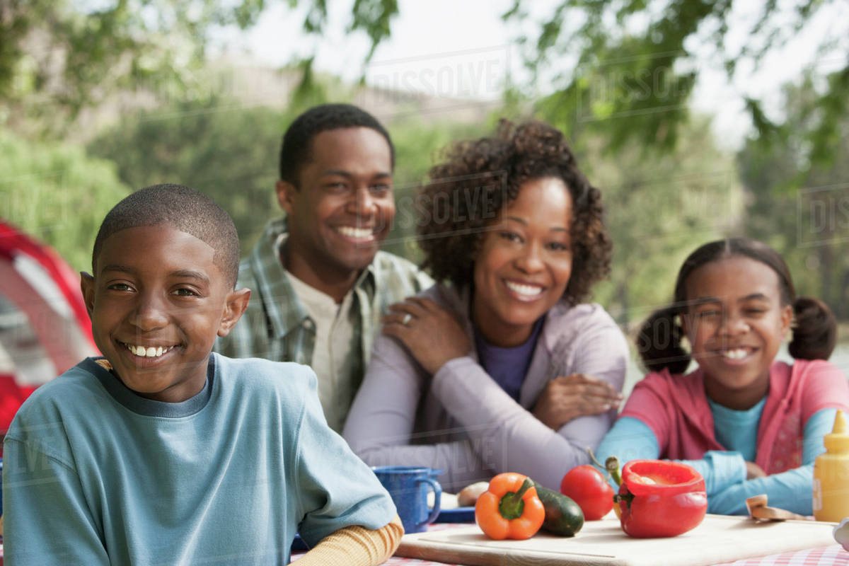 Family smiling together at campsite - Royalty-free Stock Photo | Dissolve