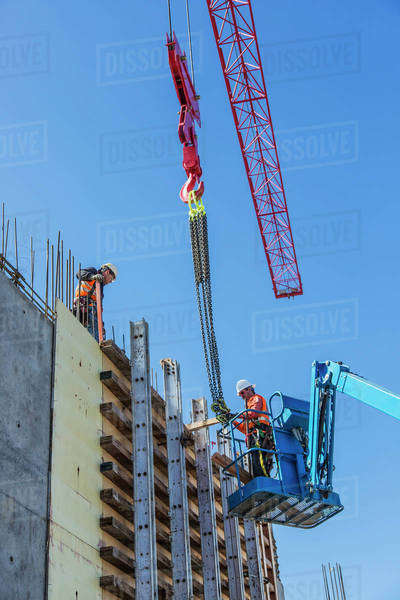 Workers on concrete wall form on construction site - Stock Photo - Dissolve
