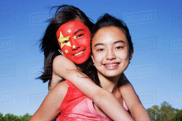Chinese girl with Chinese flag painted on face hugging friend - Royalty ...