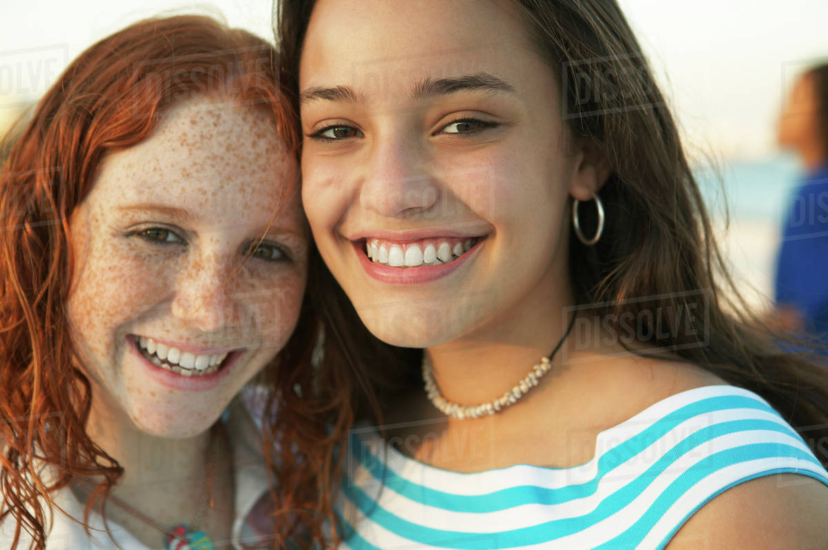 Teenage girls hugging on beach - Royalty-free Stock Photo | Dissolve