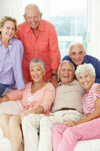 Senior friends smiling together in living room - Royalty-free Stock ...