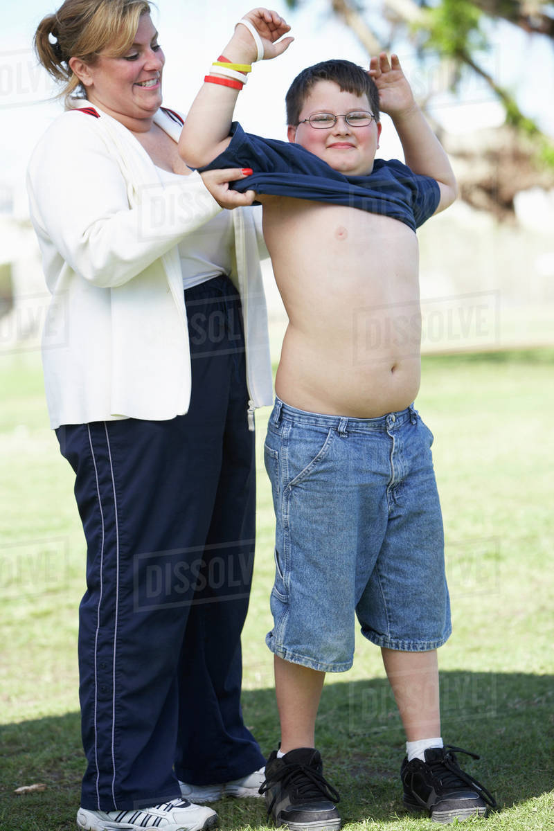 Mother helping son put on t-shirt - Royalty-free Stock Photo | Dissolve
