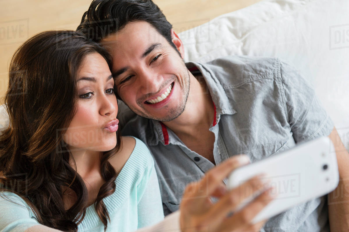 Couple taking pictures together on sofa - Royalty-free Stock Photo ...