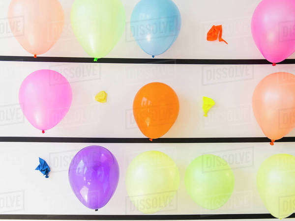 Popped balloons on wall - Stock Photo - Dissolve