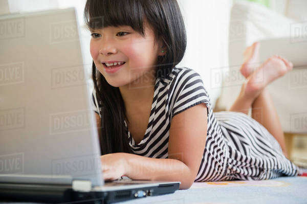 Filipino girl using laptop on floor - Royalty-free Stock Photo | Dissolve