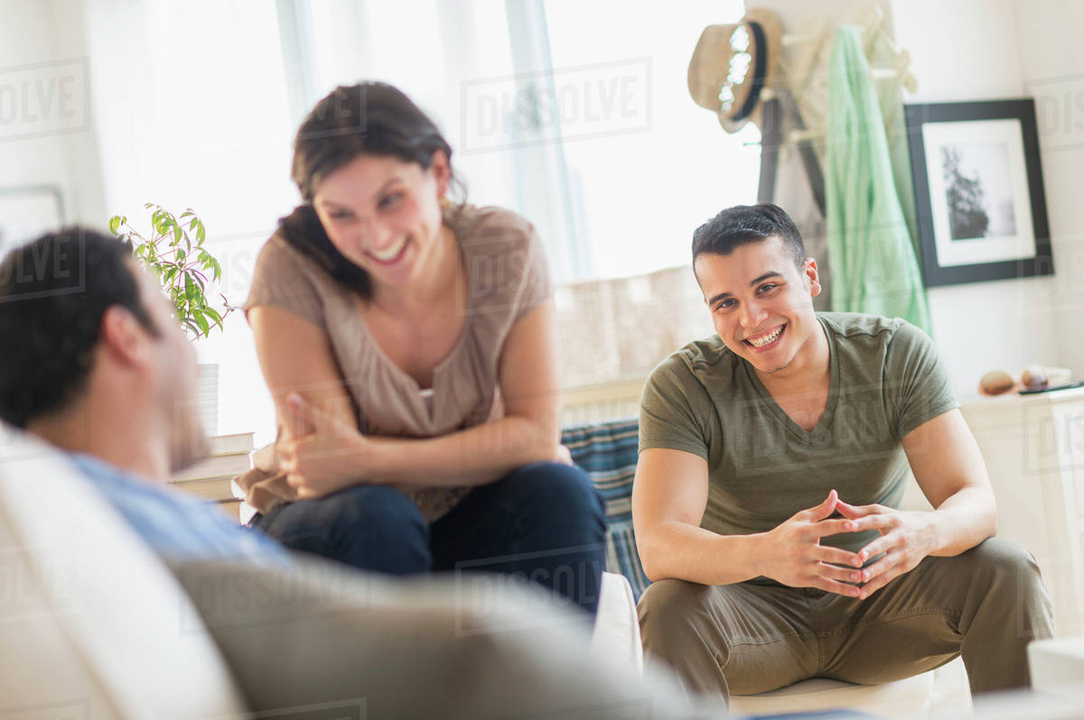 Hispanic friends talking in living room - Royalty-free Stock Photo ...