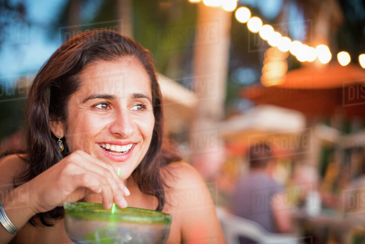 Hispanic woman drinking cocktail outdoors - Royalty-free Stock Photo ...